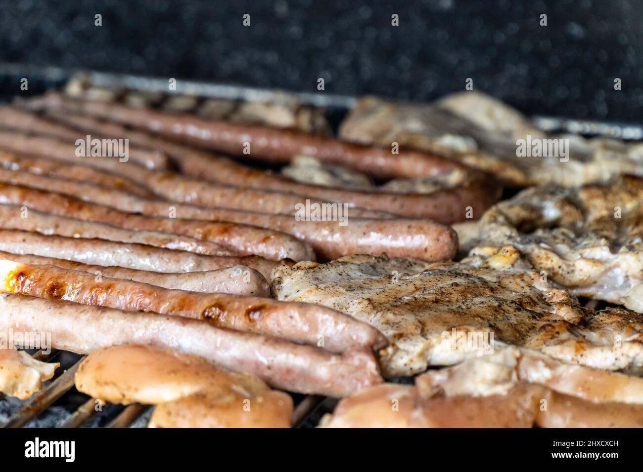 Variety of meats being grilled on a charcoal barbecue Stock Photo - Alamy