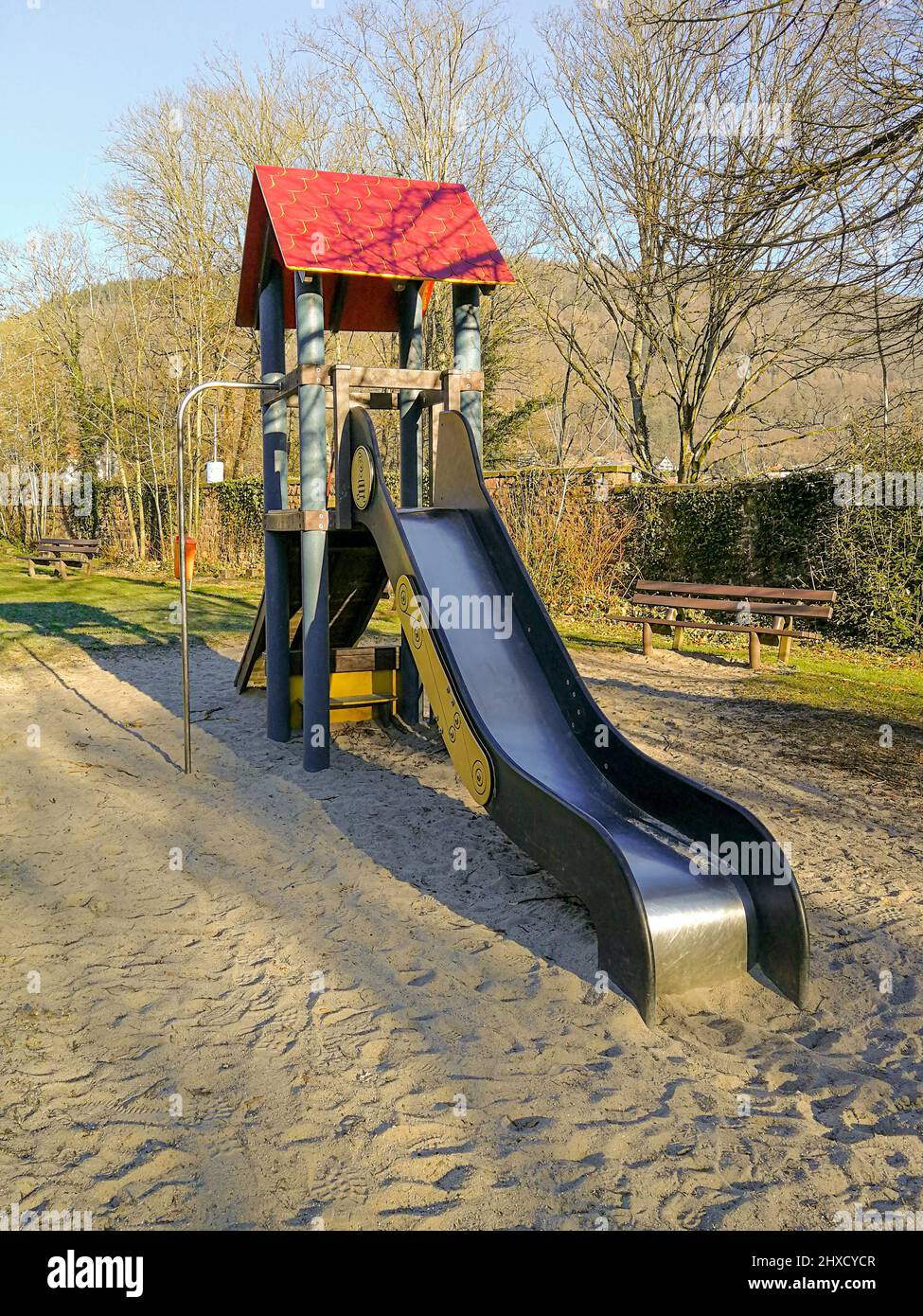 Modern slide on a children's playground with sand pit and sunshade in ...