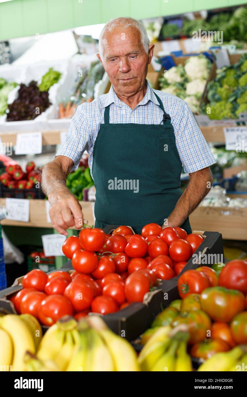 Salesman arranging fruits and vegetables on shelves Stock Photo - Alamy