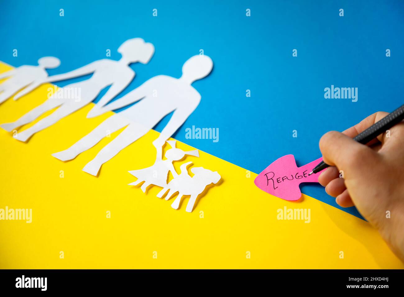 paper cutout of a family in the colors of the Ukrainian flag. concept ...
