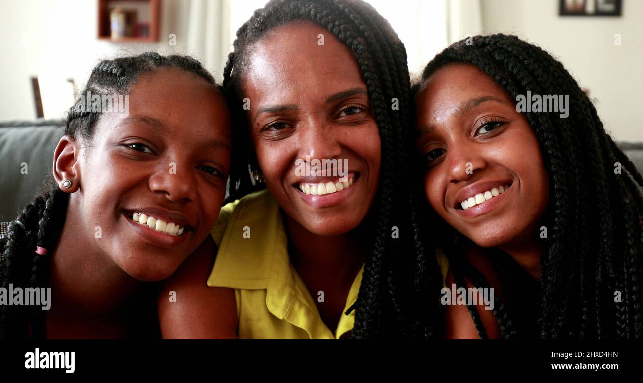 Happy African mother posing with teenage daughters together smiling ...