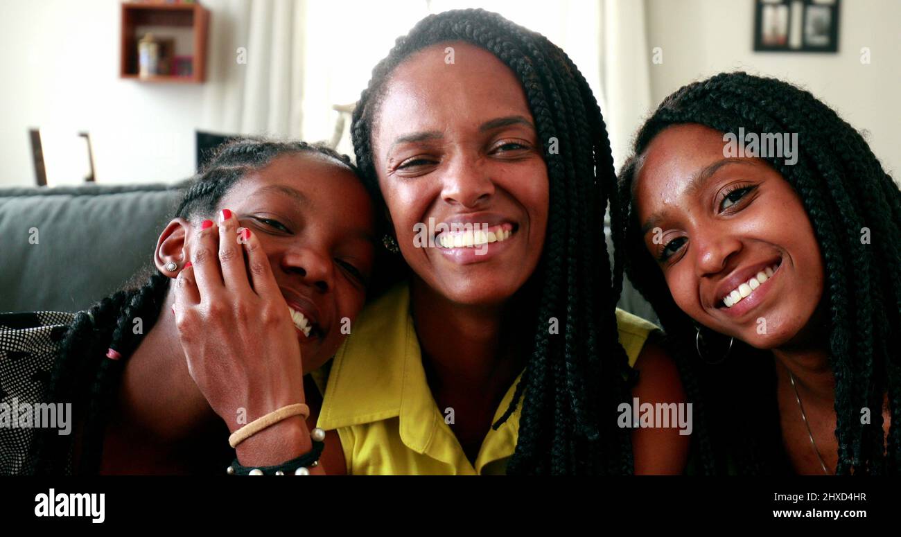 Happy African mother posing with teenage daughters together smiling ...