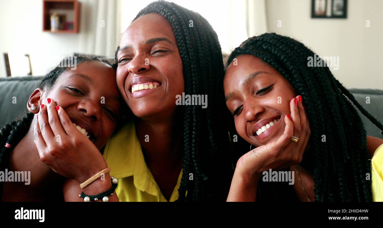 Happy African mother posing with teenage daughters together smiling ...
