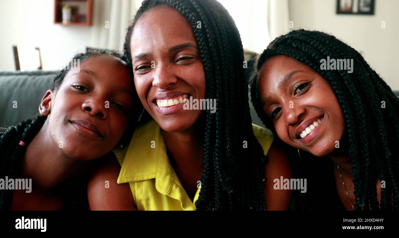 Happy African mother posing with teenage daughters together smiling ...