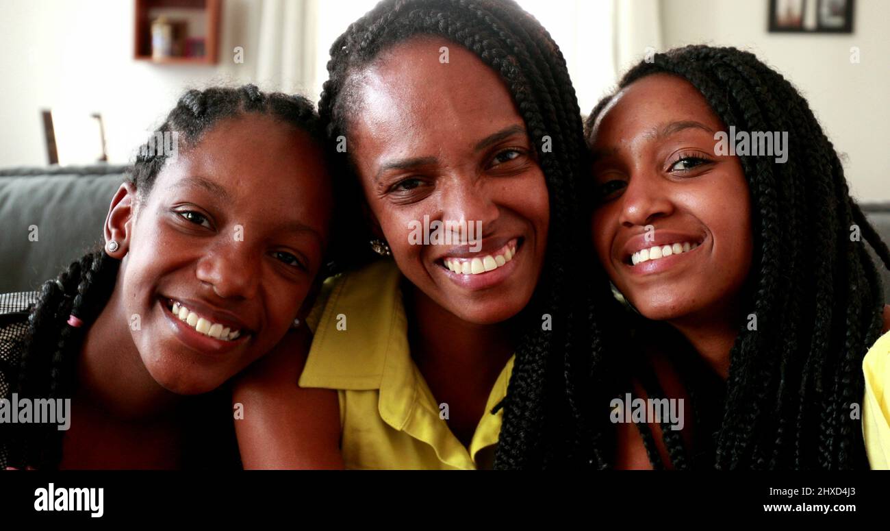 Happy African mother posing with teenage daughters together smiling ...