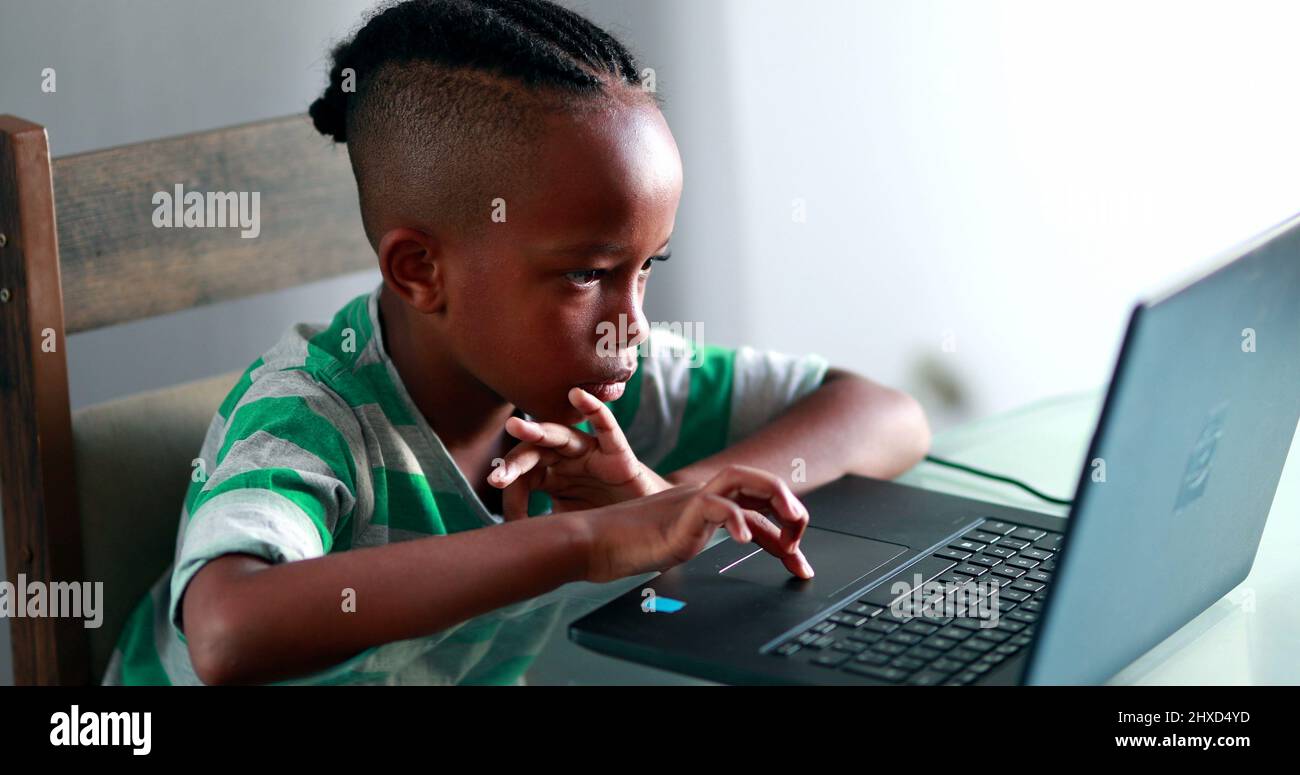 Little boy browsing internet on laptop. Black African ethnicity kid ...