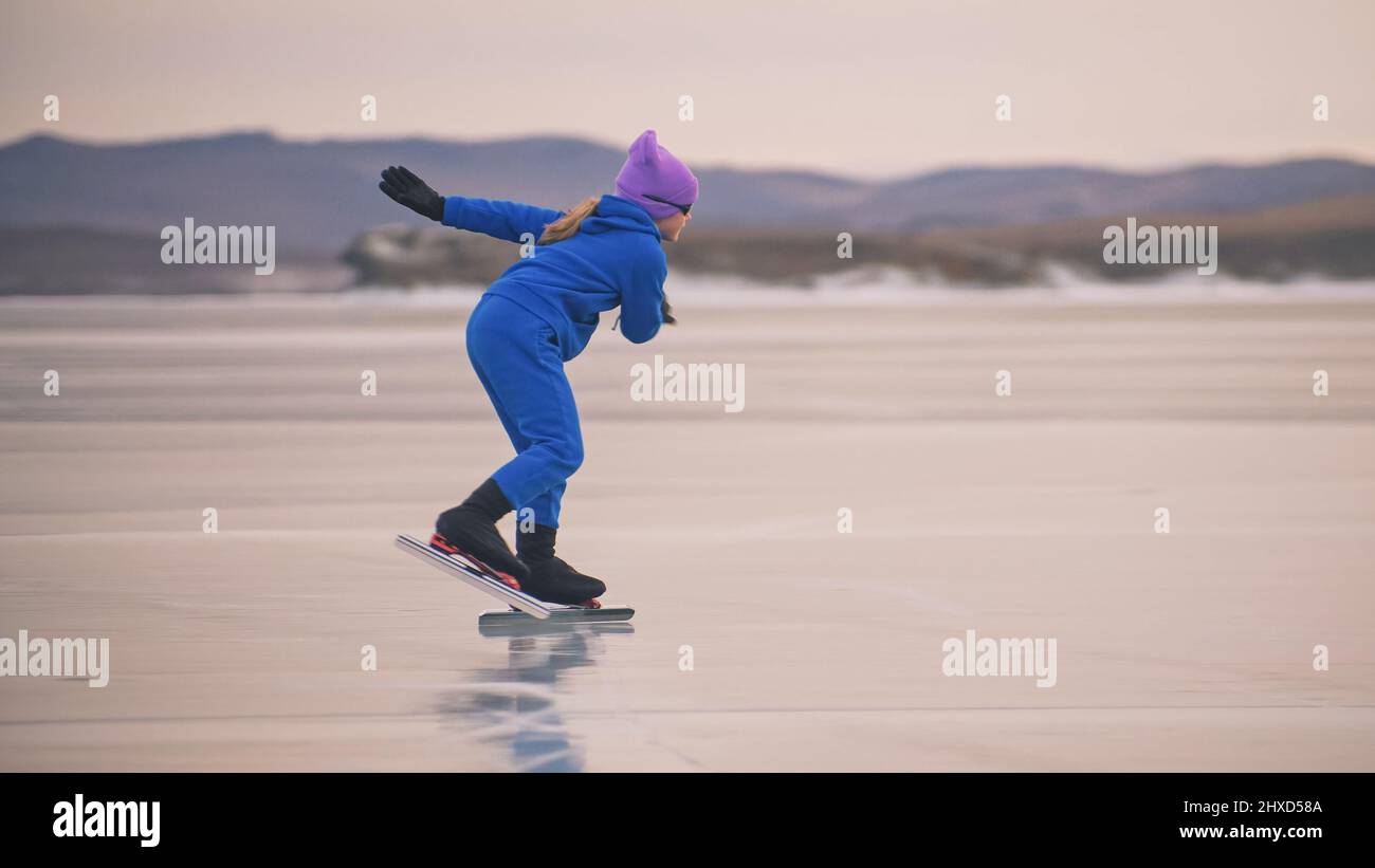 The child train on ice professional speed skating. The girl skates in ...