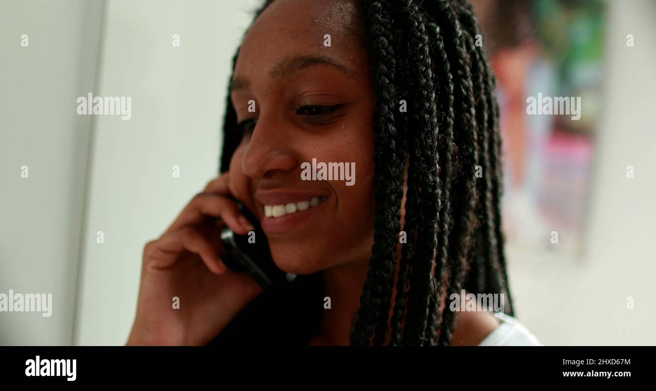 Teen girl answering phone call. African adolescent girl talking on ...