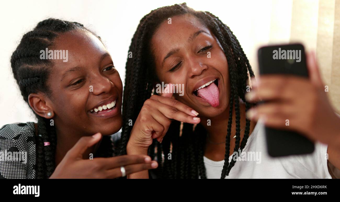 Two best friends taking selfie with cellphone, girlfriends making funny ...