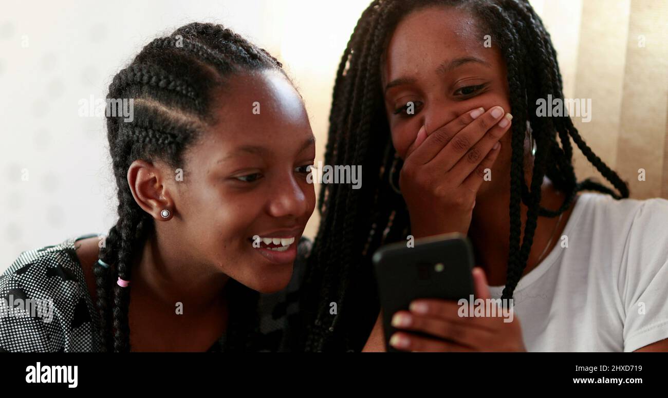 Two girls with shock reaction looking at cellphone defice. Teenage ...