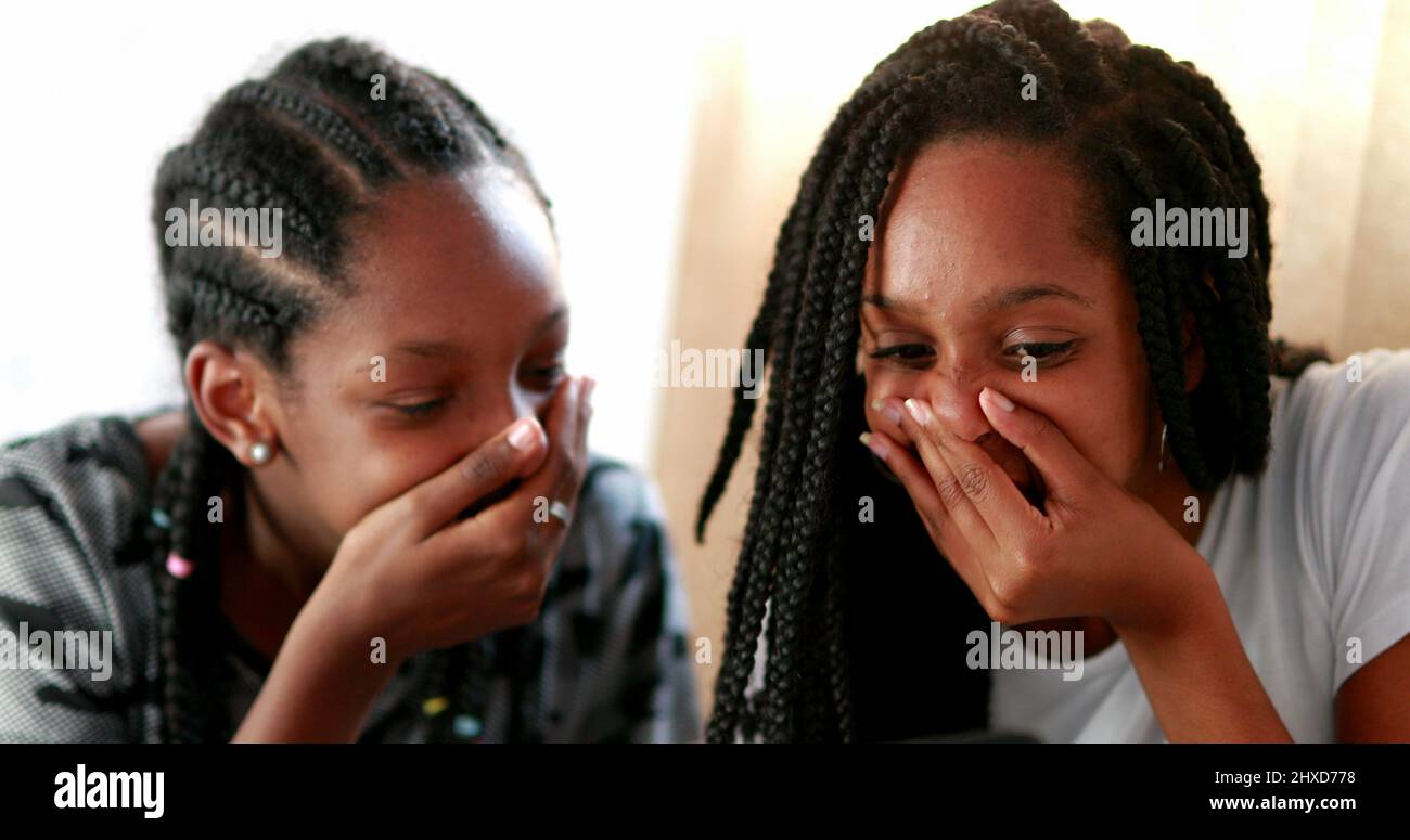 Two teen African girls reacting with shock to news on smartphone ...