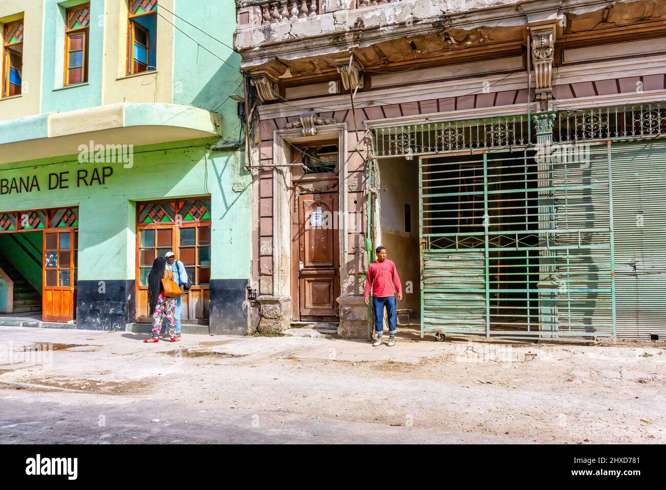 Cuban people by an architectural contrast, old building with metal ...