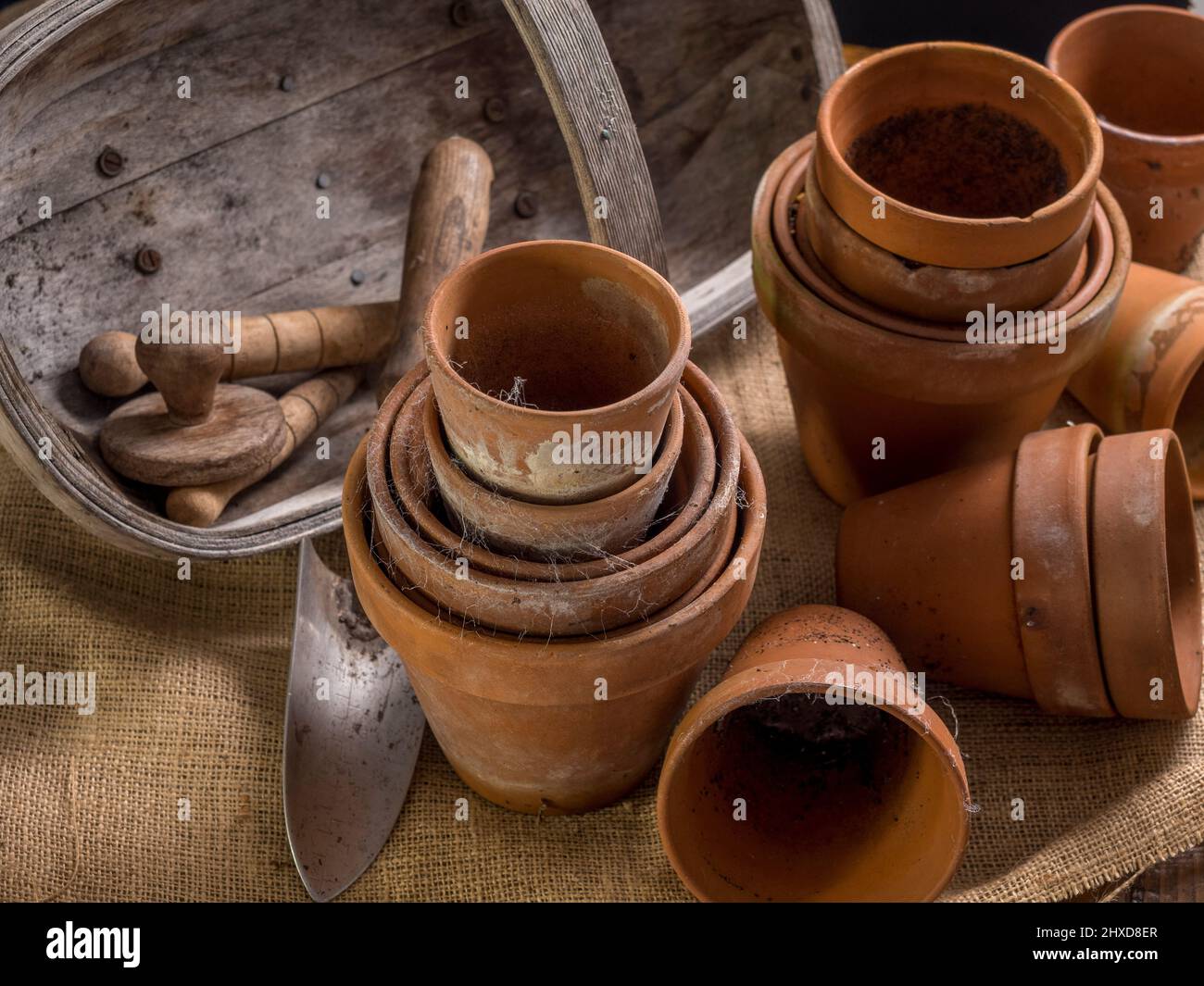 Cobweb covered terracotta plant pots with trowel and traditional wooden ...