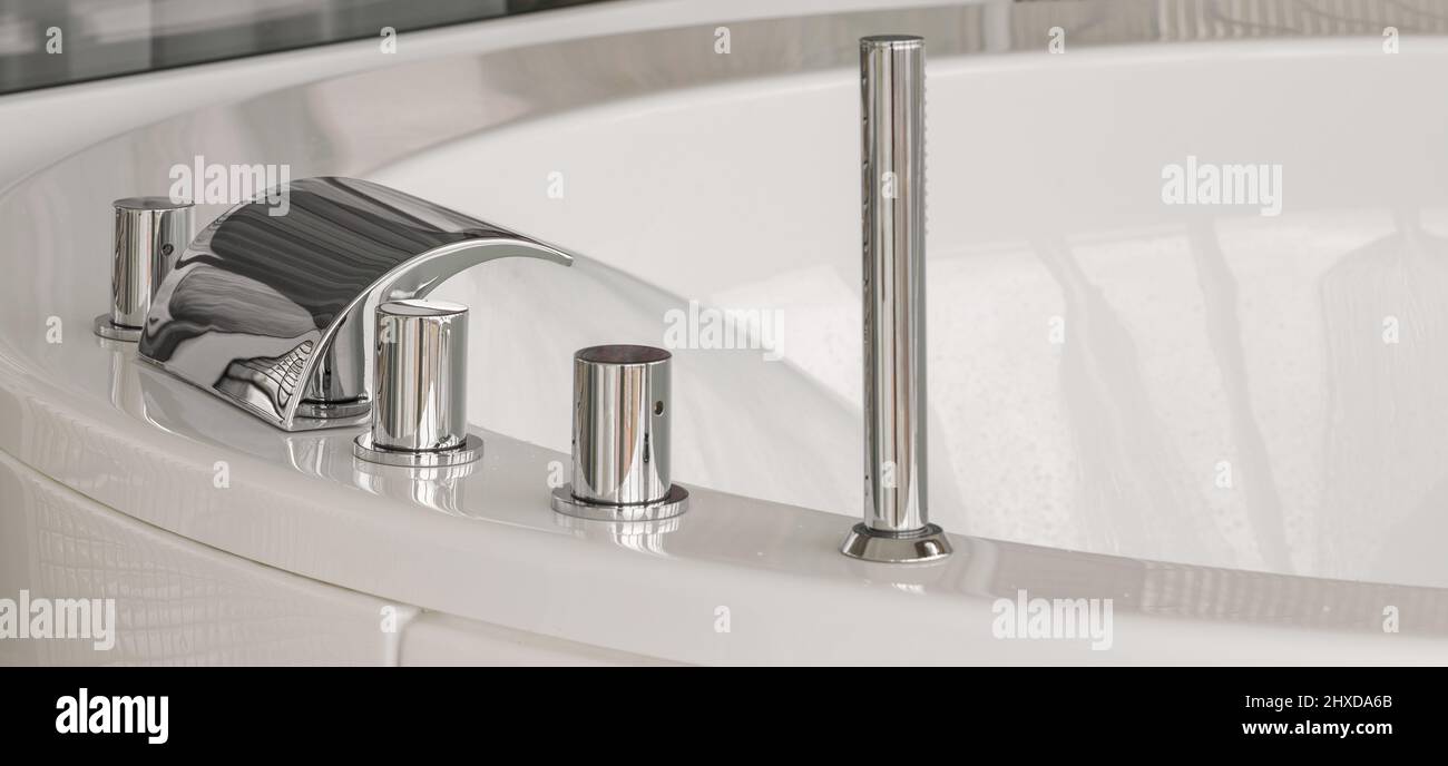 Water flows from a luxurious modern water faucet into a large modern ...