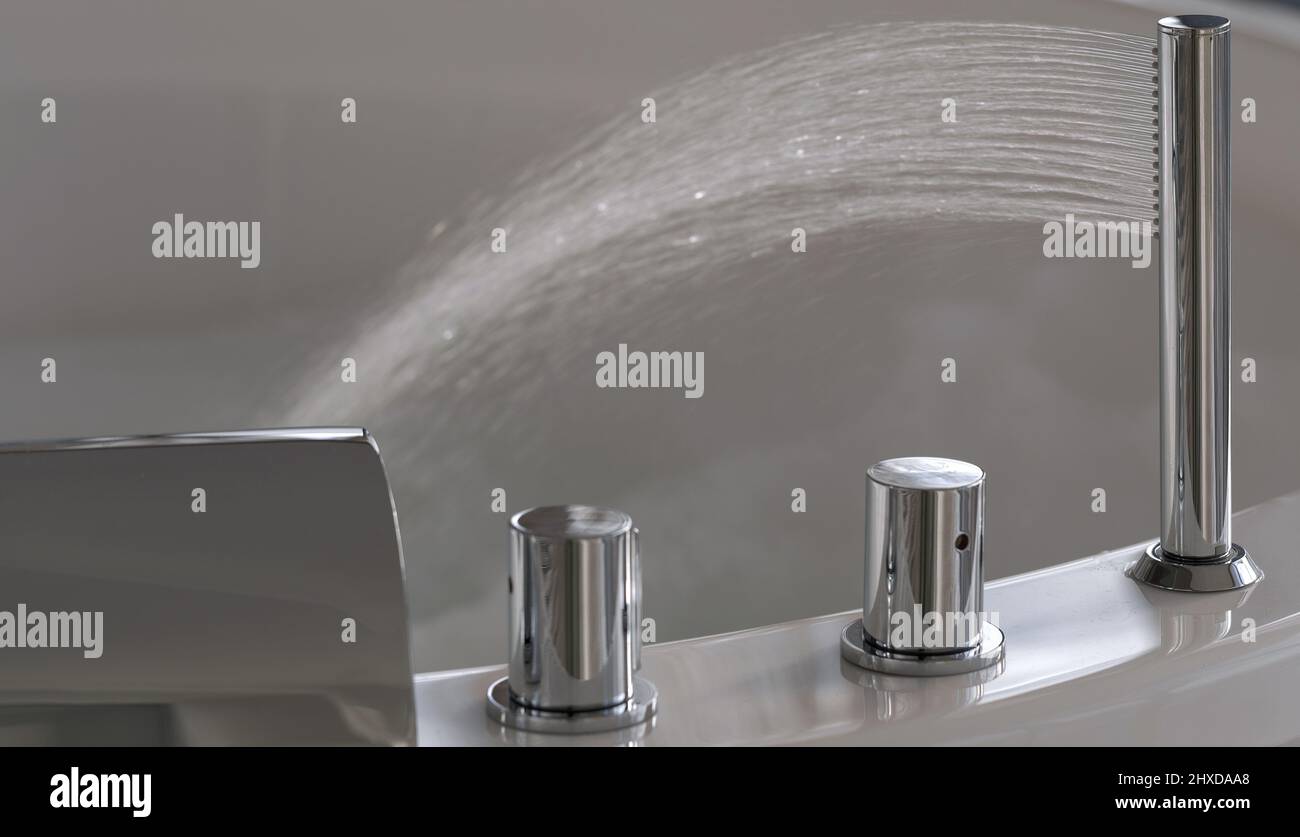 Water flows from a luxurious modern water faucet into a large modern ...