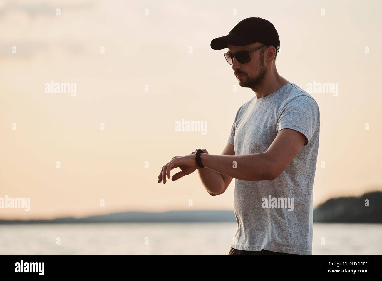 sporty man looking at his smart fitness watch Stock Photo - Alamy