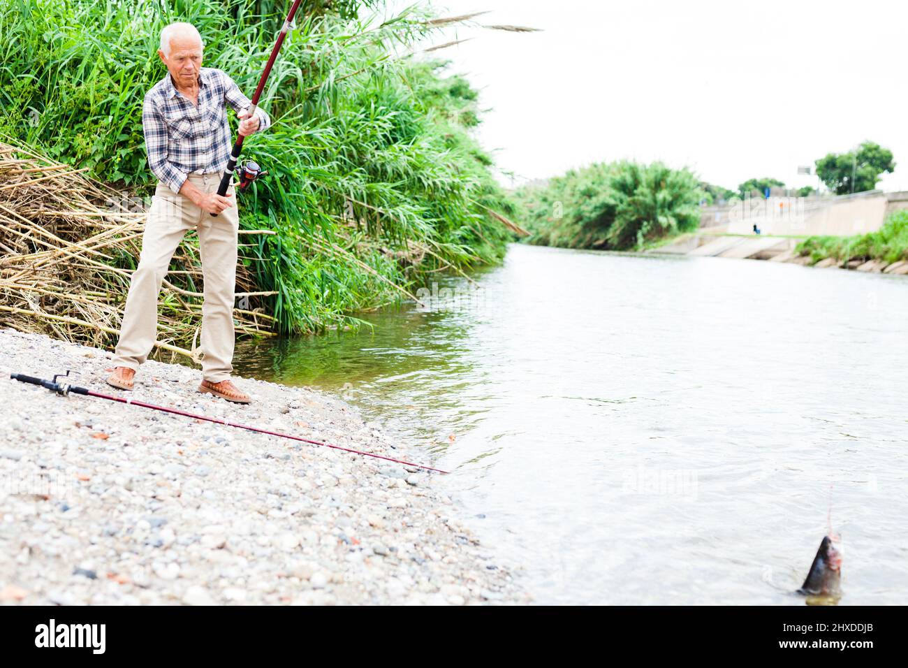 Fisherman pulling fish from river Stock Photo - Alamy