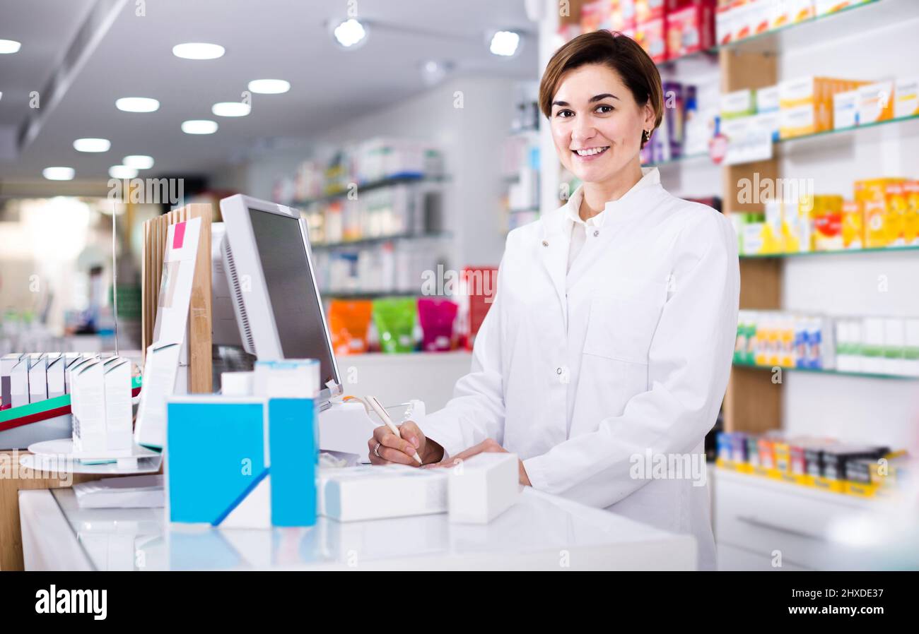 female pharmacist checking assortment of drugs in pharmacy Stock Photo ...