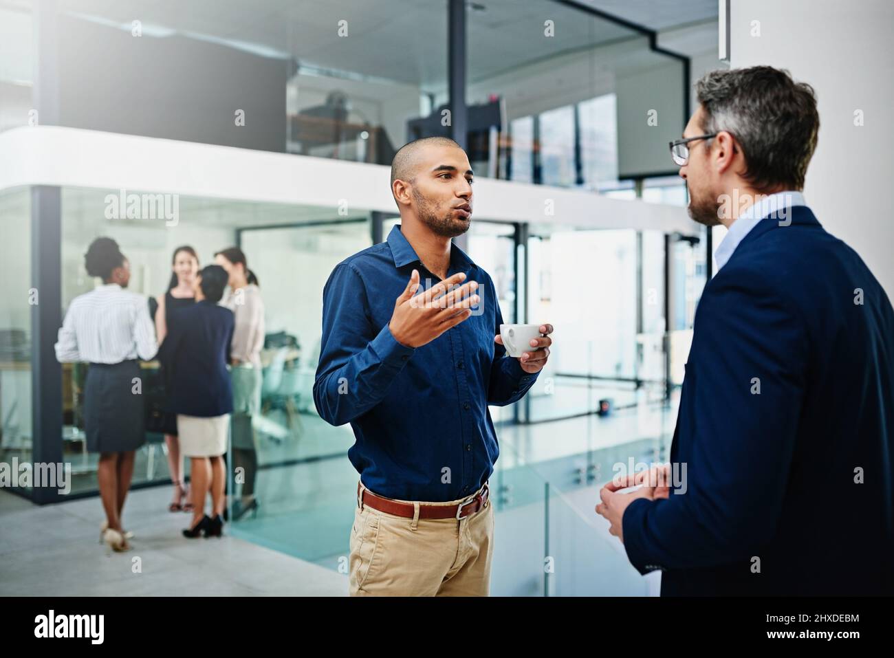 Colleagues discussing something during coffee hi-res stock photography ...