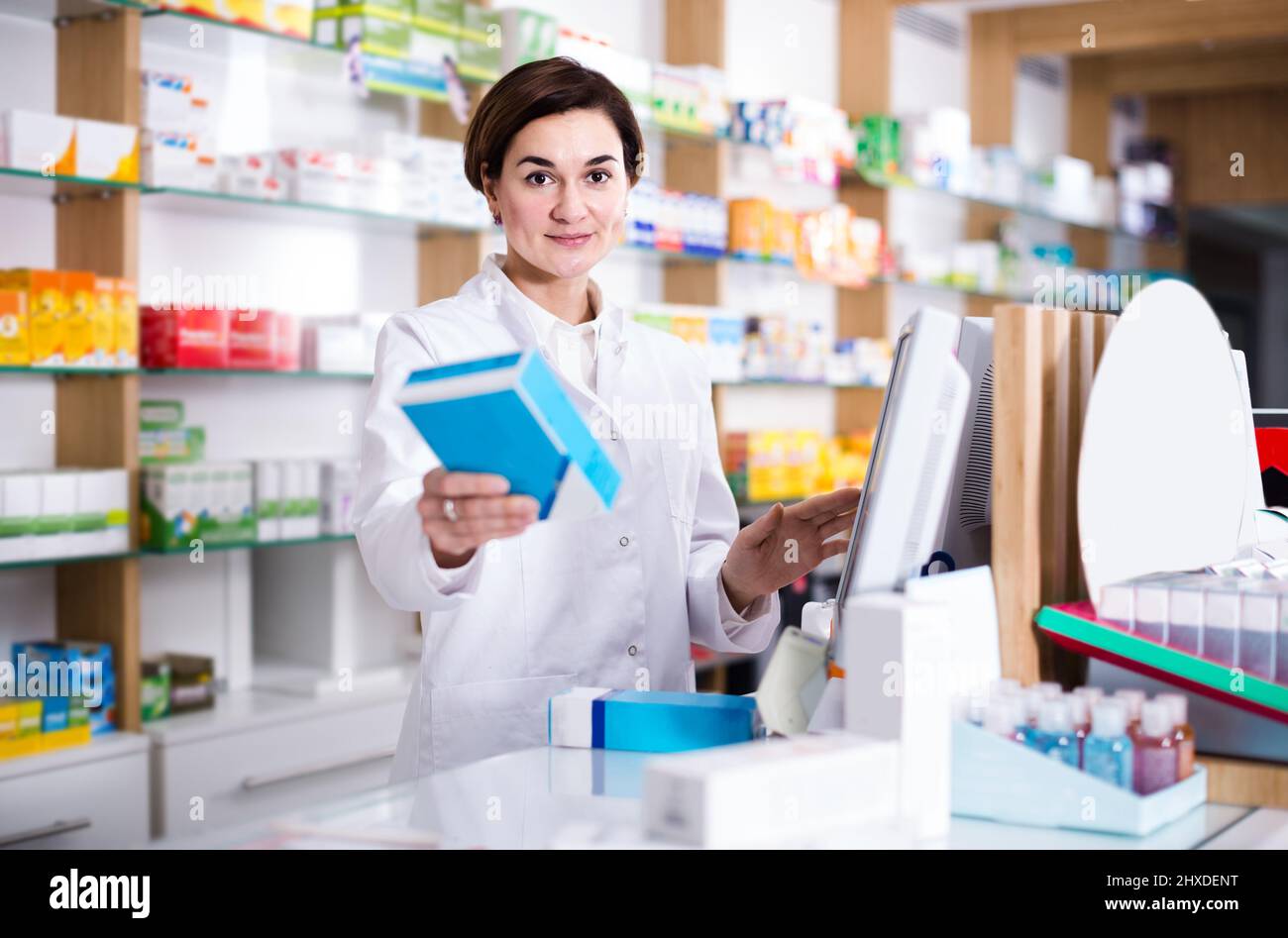female pharmacist offering assistance at counter in pharmacy Stock ...