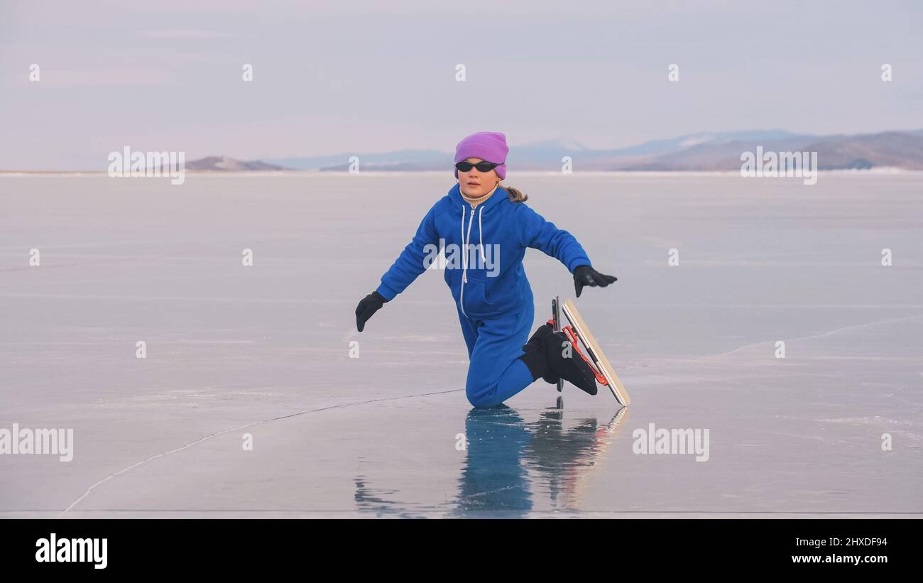 The child train on ice speed skating. The athlete stretches, warms up ...