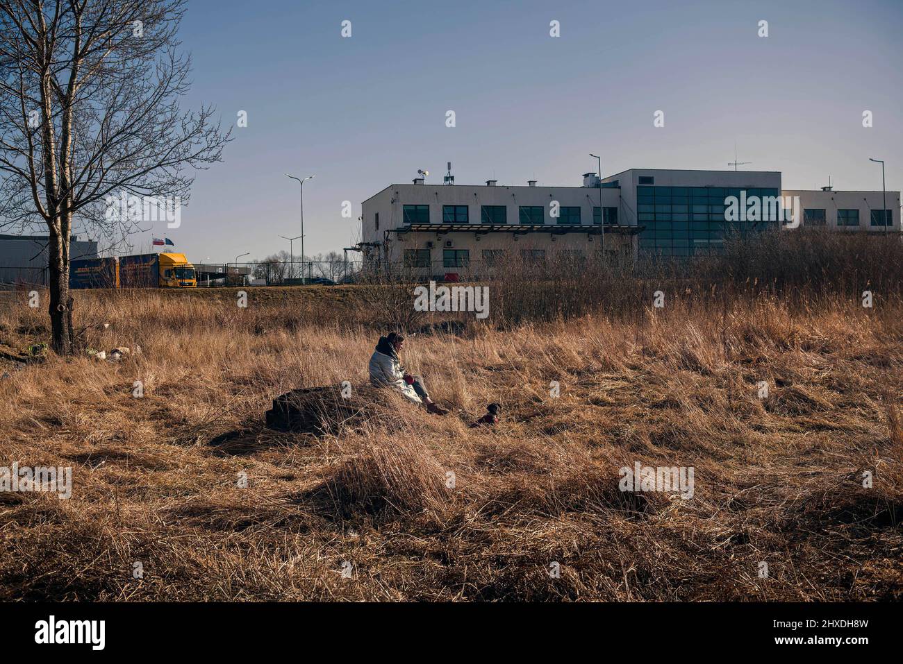 Medyka, Poland. 11th Mar, 2022. A woman sits with her dog next to the ...