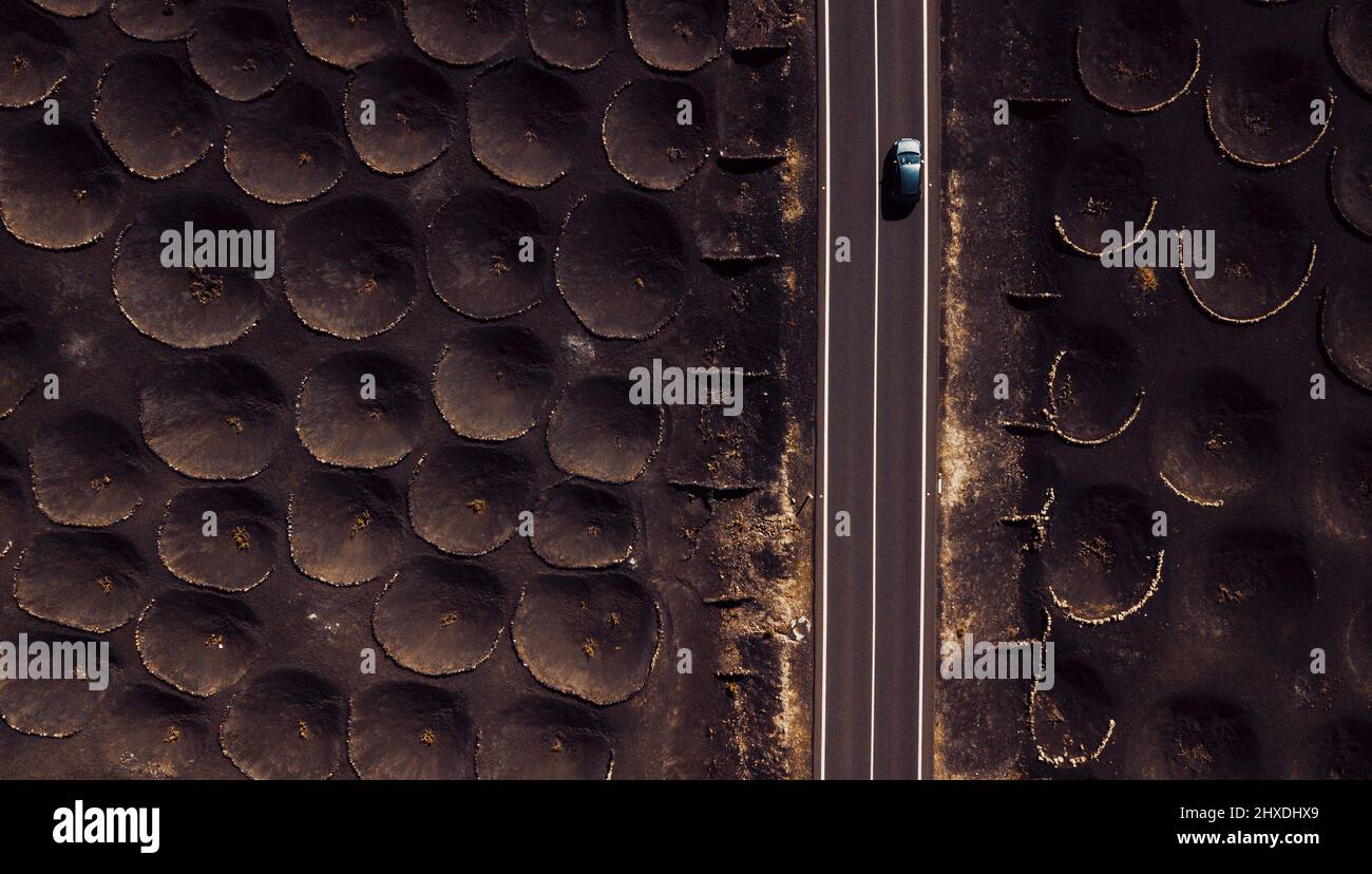 Lunar landscape concept with long asphalt road and car traveling. Rare ...