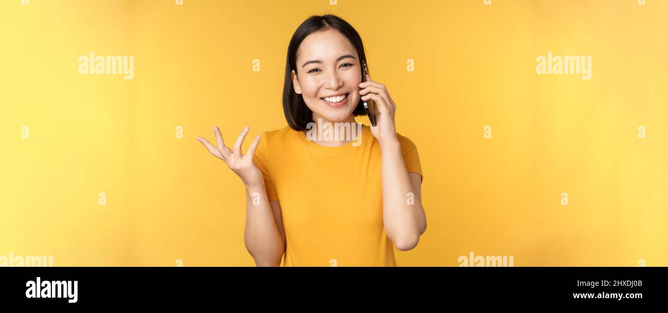 Young korean girl talking on mobile phone. Asian woman calling on ...