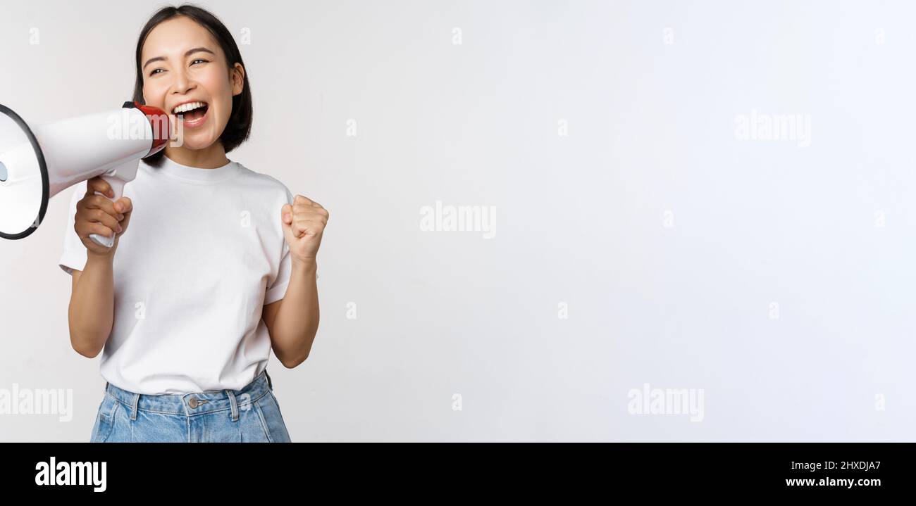 Asian girl shouting at megaphone, young activist protesting, using loud ...