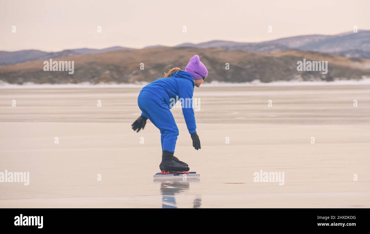 The child train on ice professional speed skating. The girl skates in ...