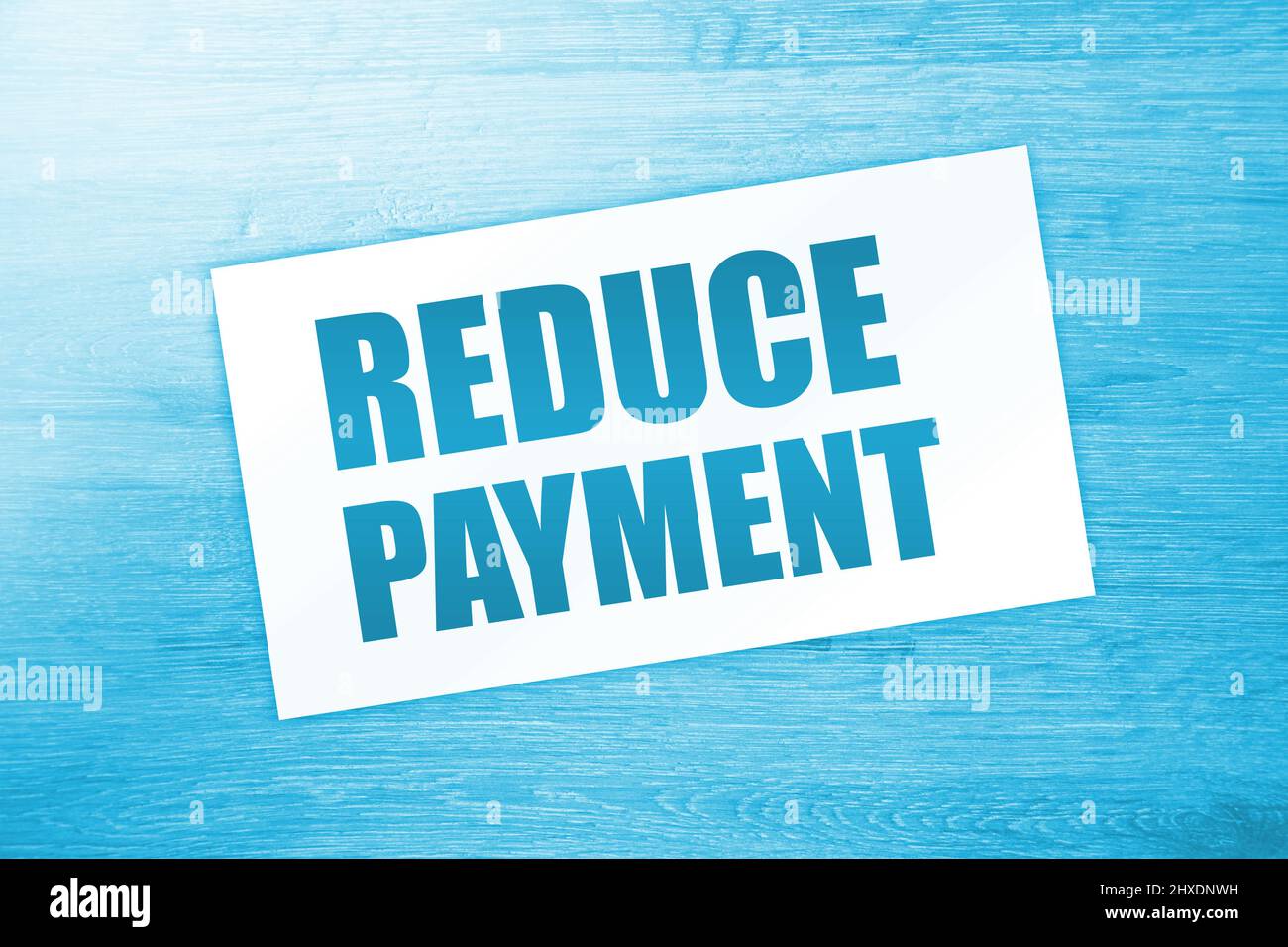 Reduce payment text on card on wooden background. business concept ...