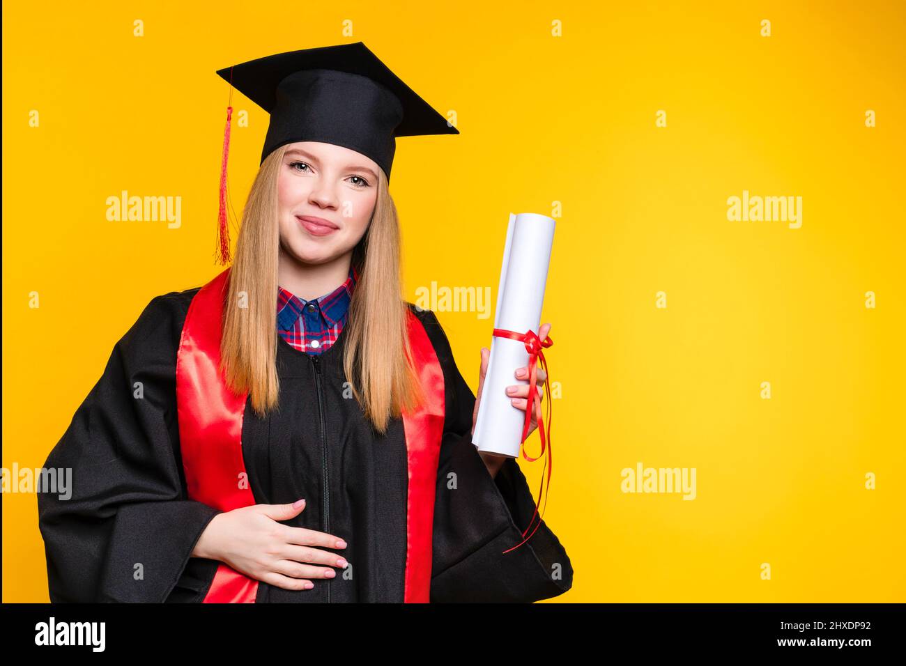 Portrait girl graduate with graduation hat and diploma on yellow ...