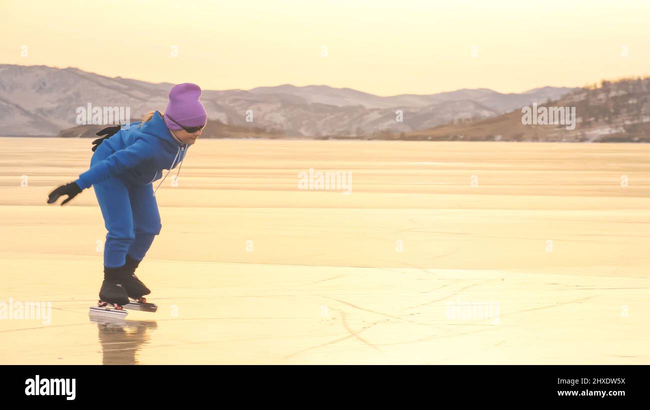 The child train on ice professional speed skating. The girl skates in ...