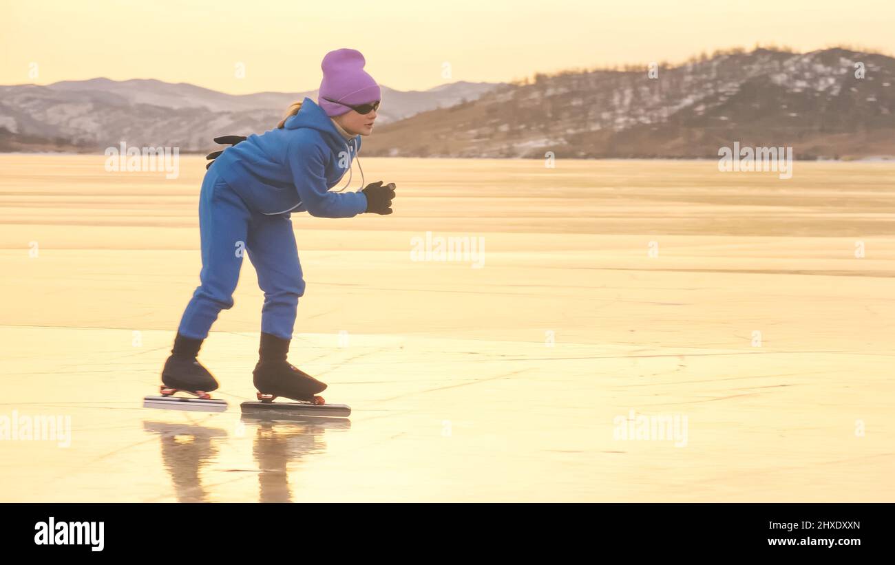 The child train on ice professional speed skating. The girl skates in ...