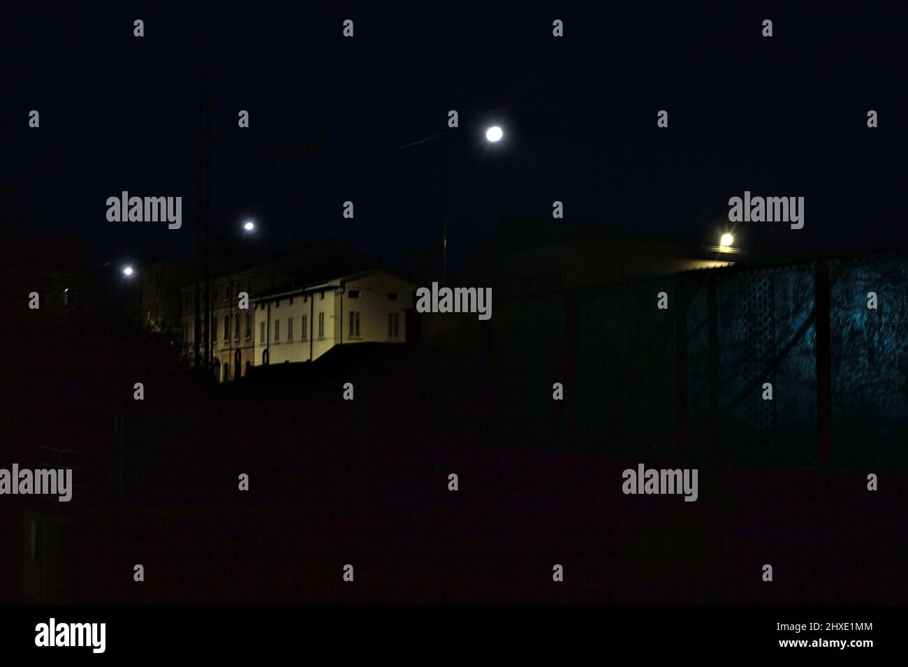 Old building lit by street lights in the distance at night Stock Photo ...