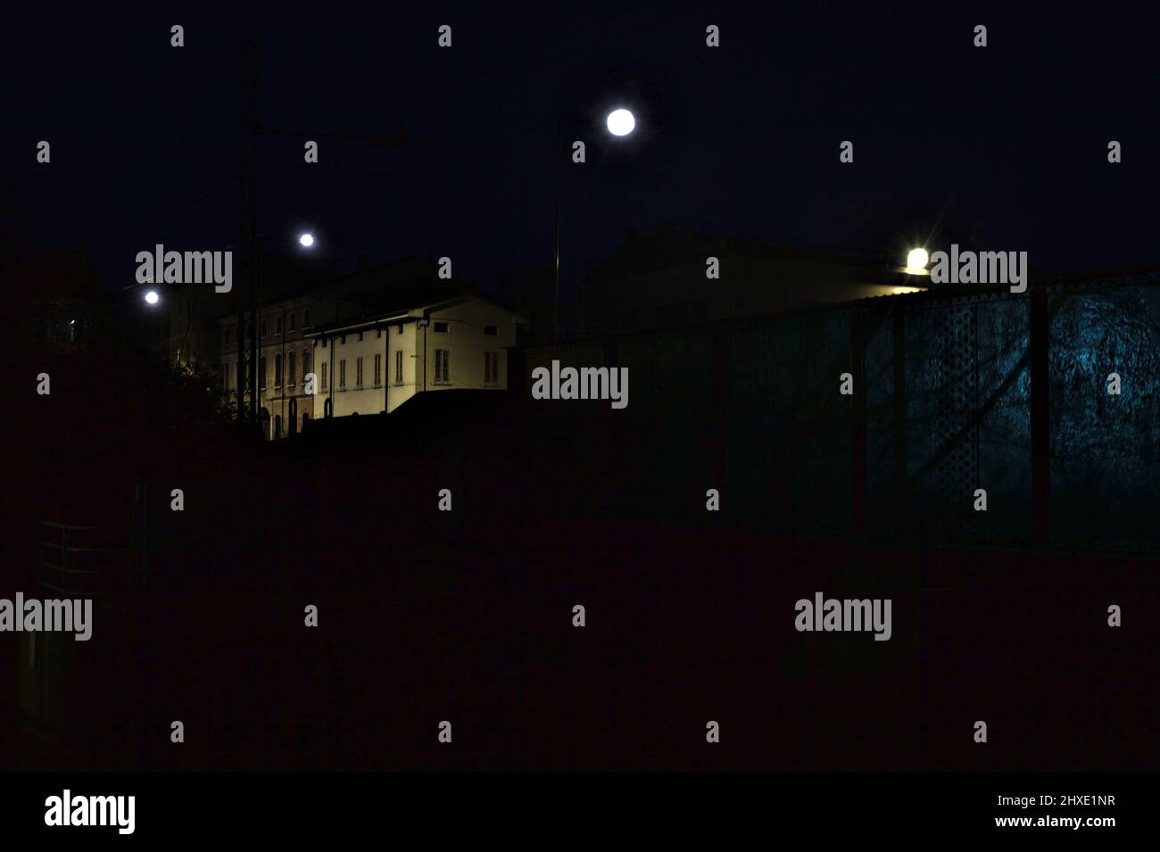 Old building lit by street lights in the distance at night Stock Photo ...