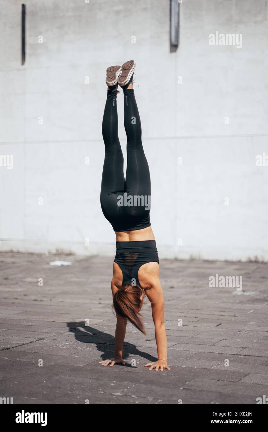 Powerful girl doing advance acrobat skills in the city. Urban ...