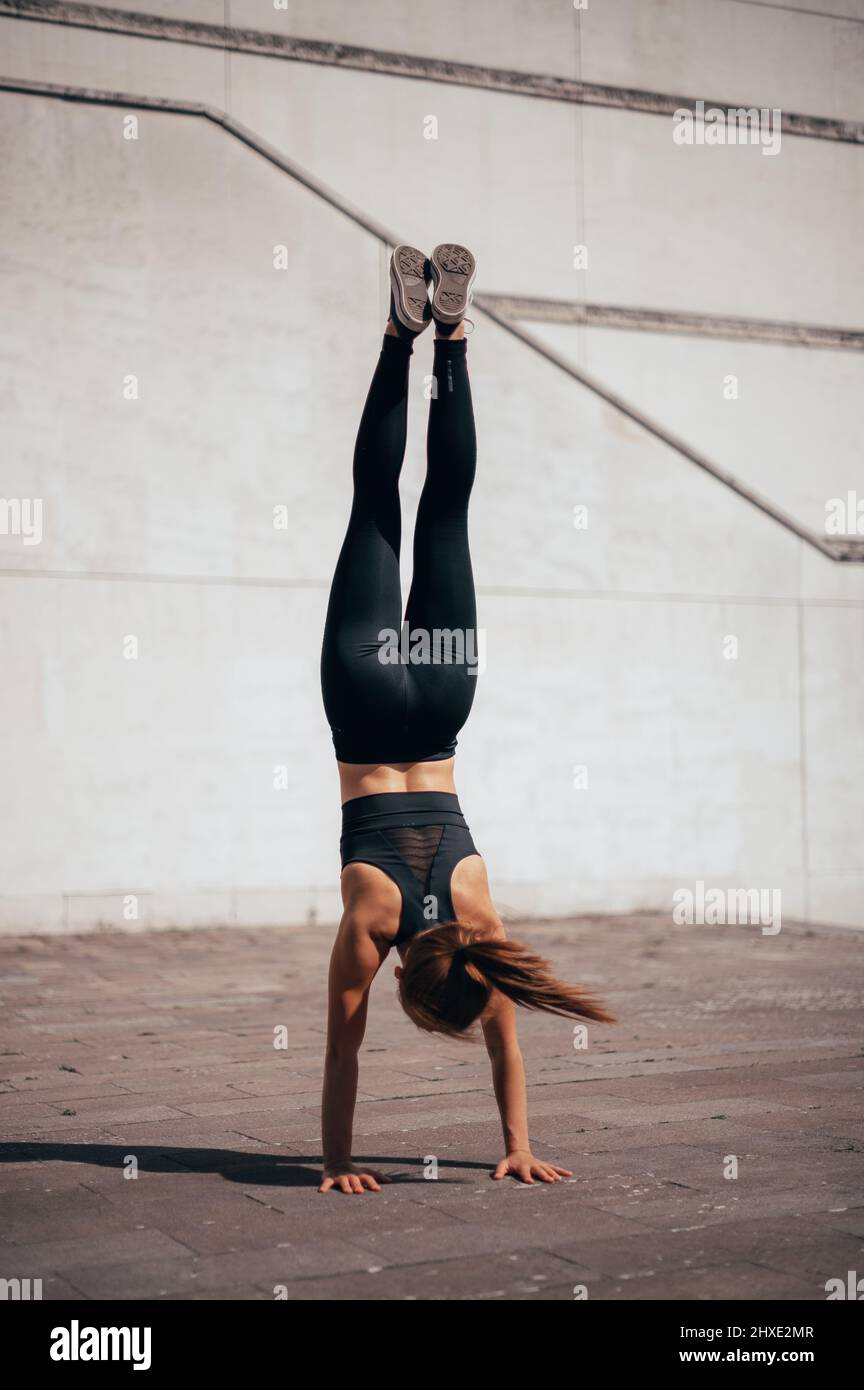 parkour woman doing handstand in the city. Urban background . Vertical ...