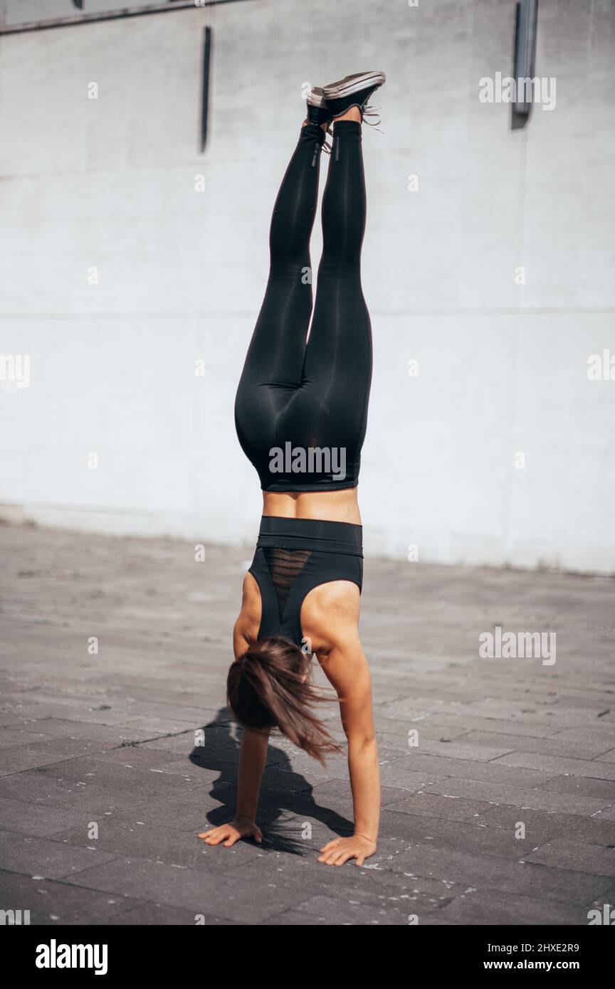 Powerful girl doing advance acrobat skills in the city. Urban ...