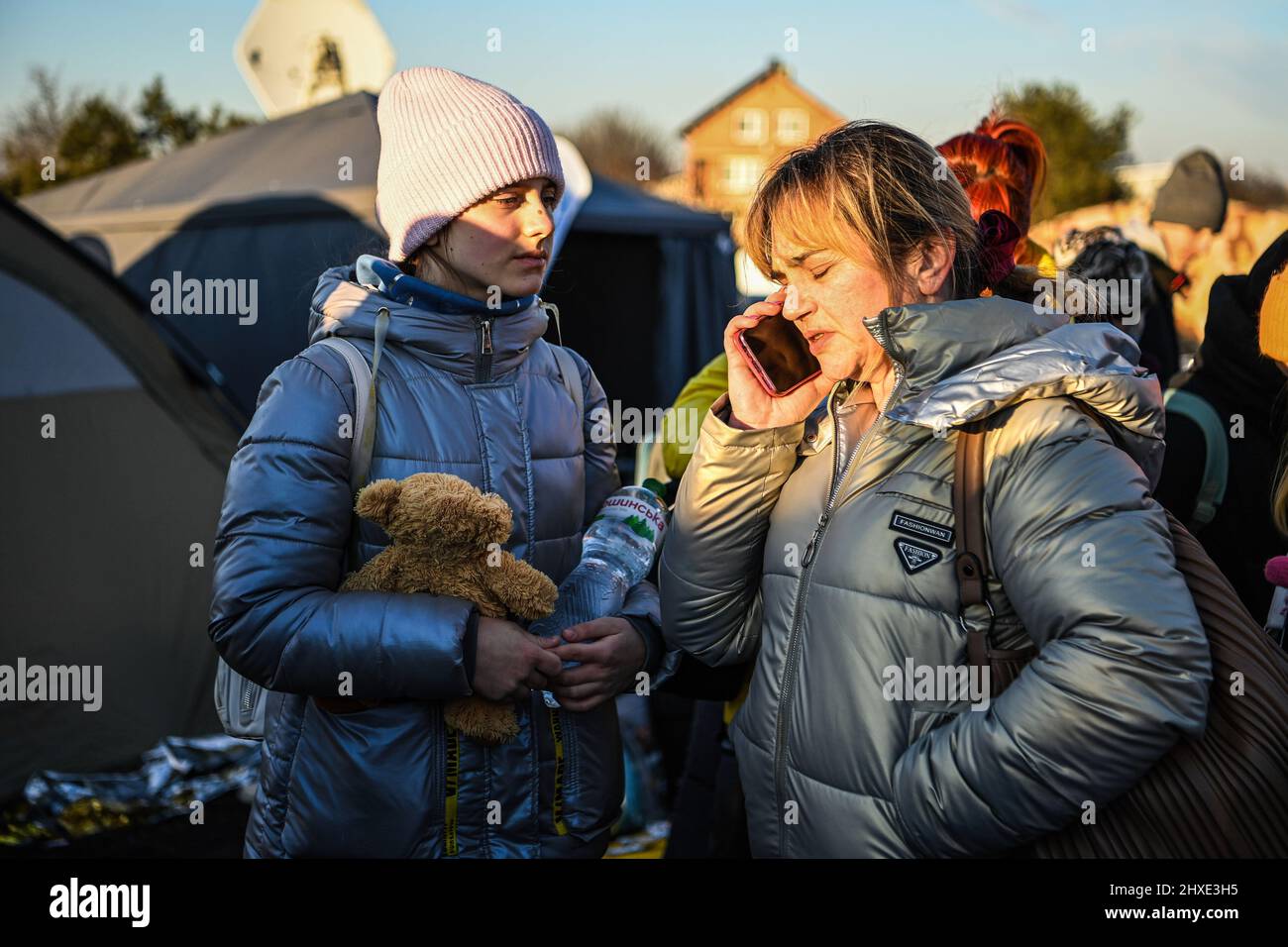 Medyka, Poland. 11th Mar, 2022. A woman talks on her phone as she waits ...