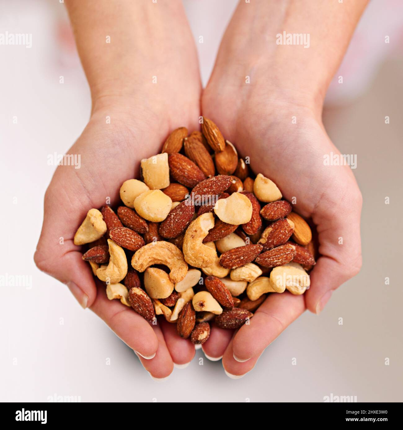 Nuts about nuts. Cropped shot of a bunch of mixed nuts in a persons ...