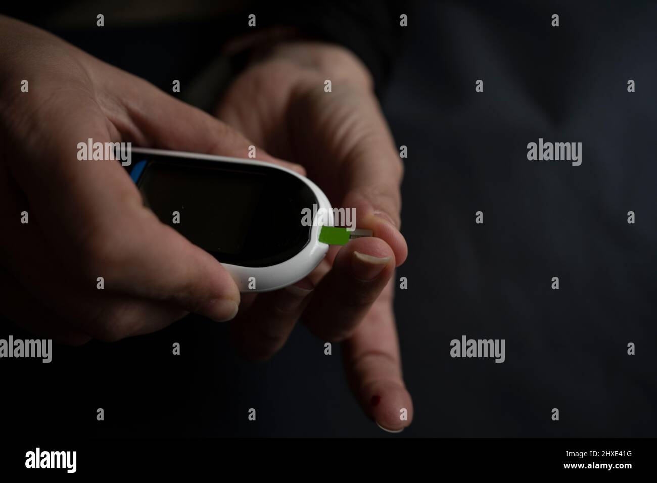 Diabetes checking blood sugar level. Woman using lancelet and ...