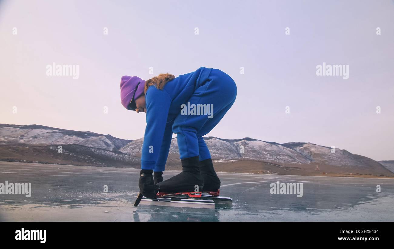 The child train on ice speed skating. The athlete at the start, in a ...