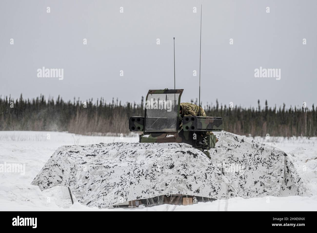 An arctic camouflage tarp covers an Avenger air defense system during ...