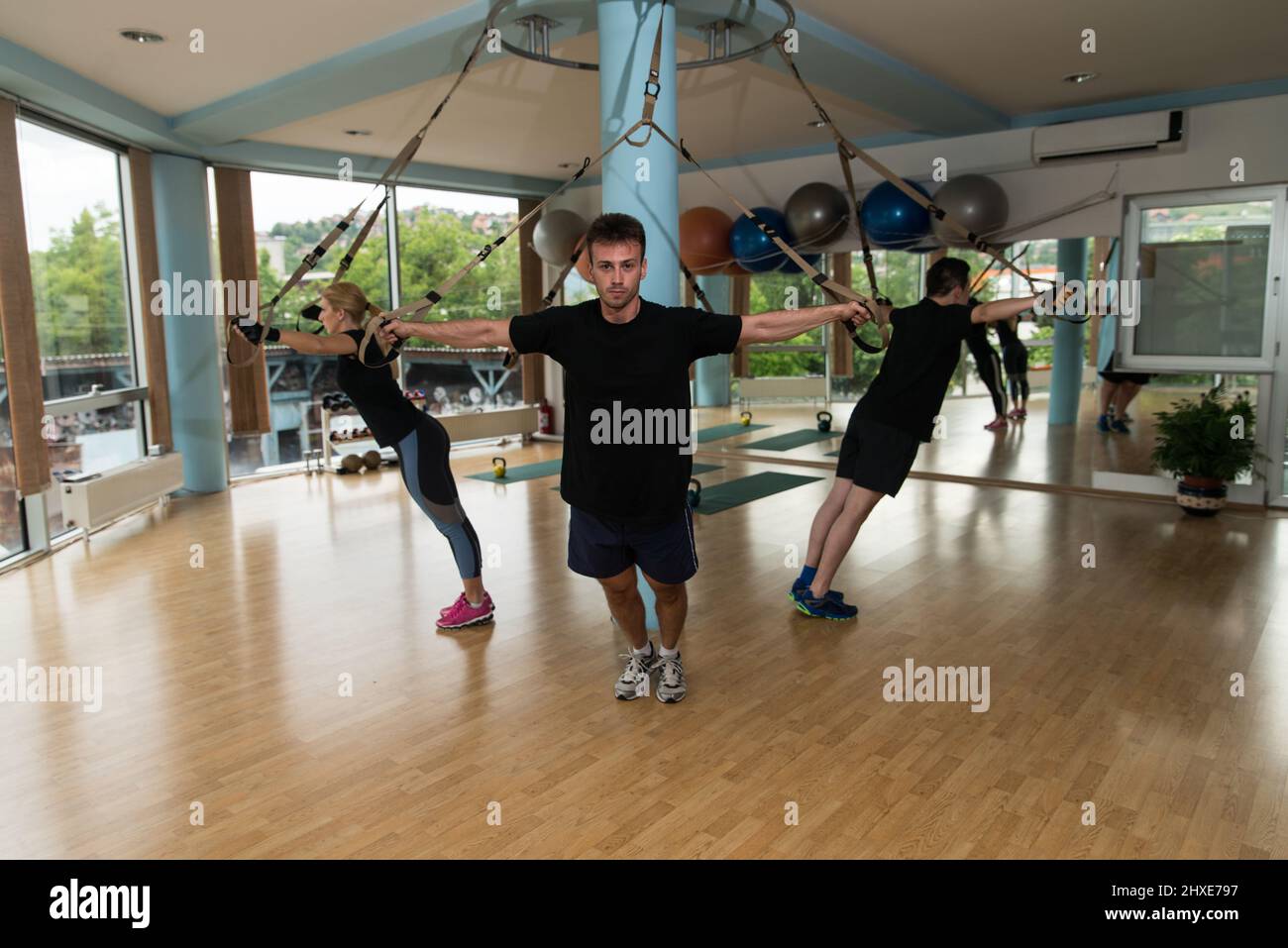 Group of Sports People Is Working Out With Trx Fitness Straps in Gym ...