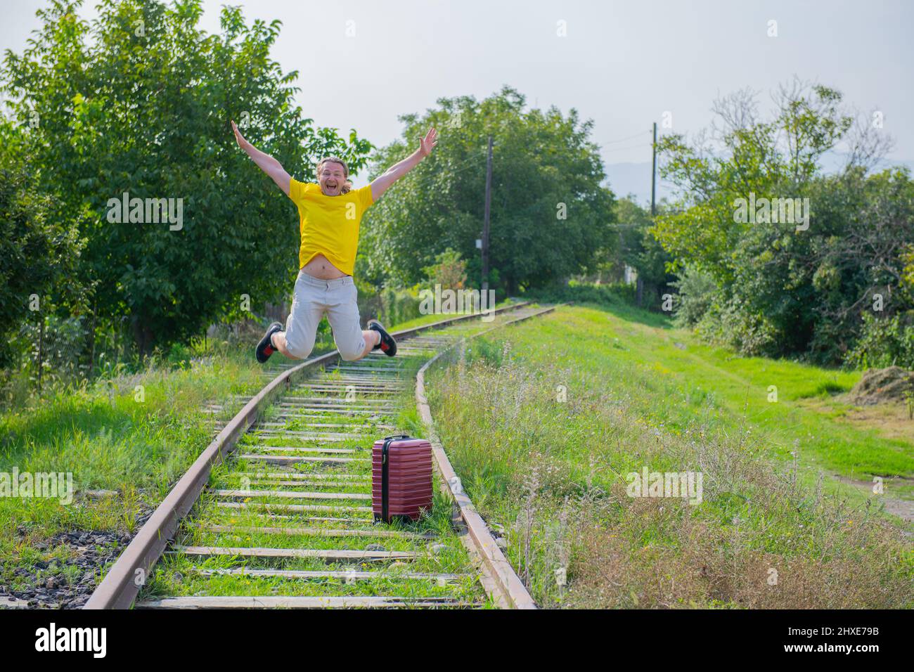 reckless tourist with a suitcase jumping on the railroad Stock Photo ...