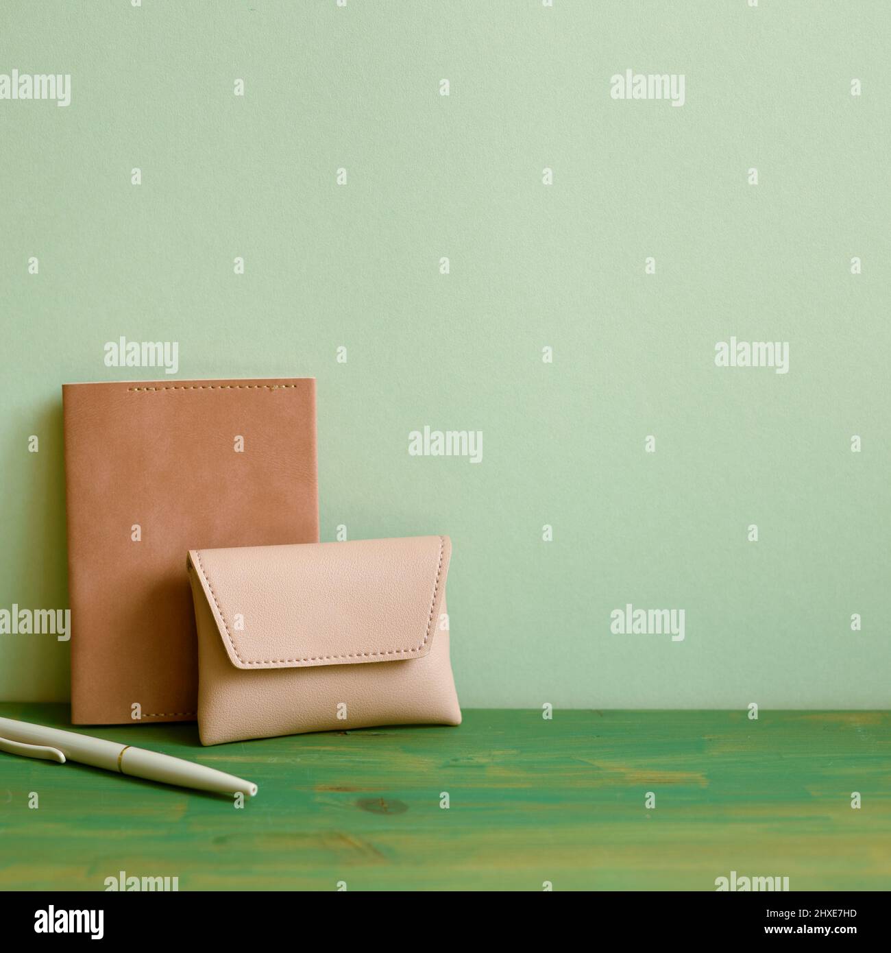 Note, pen, card wallet on wooden desk. green wall background Stock ...
