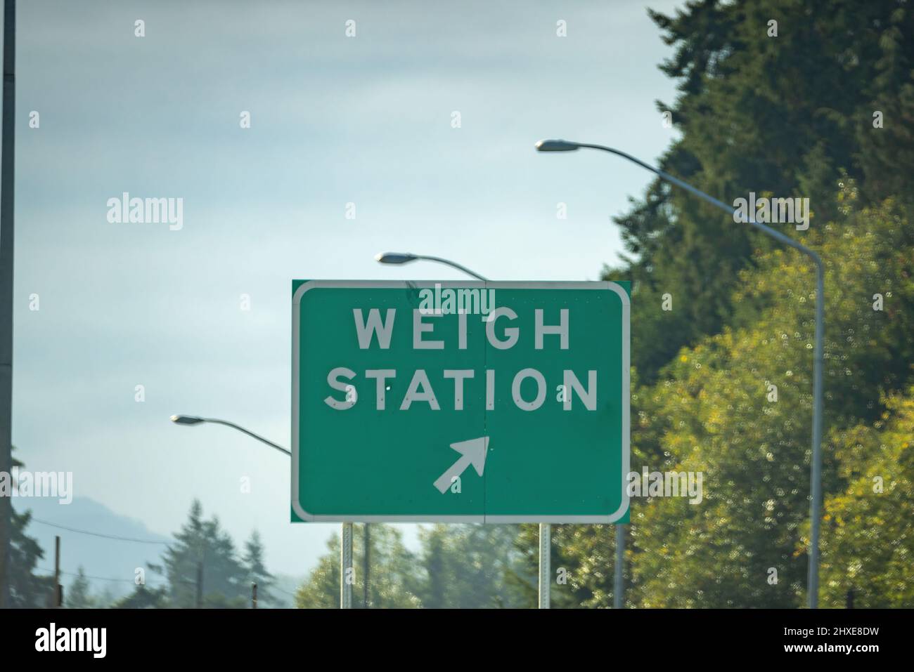 weigh station sign near green forest Stock Photo - Alamy