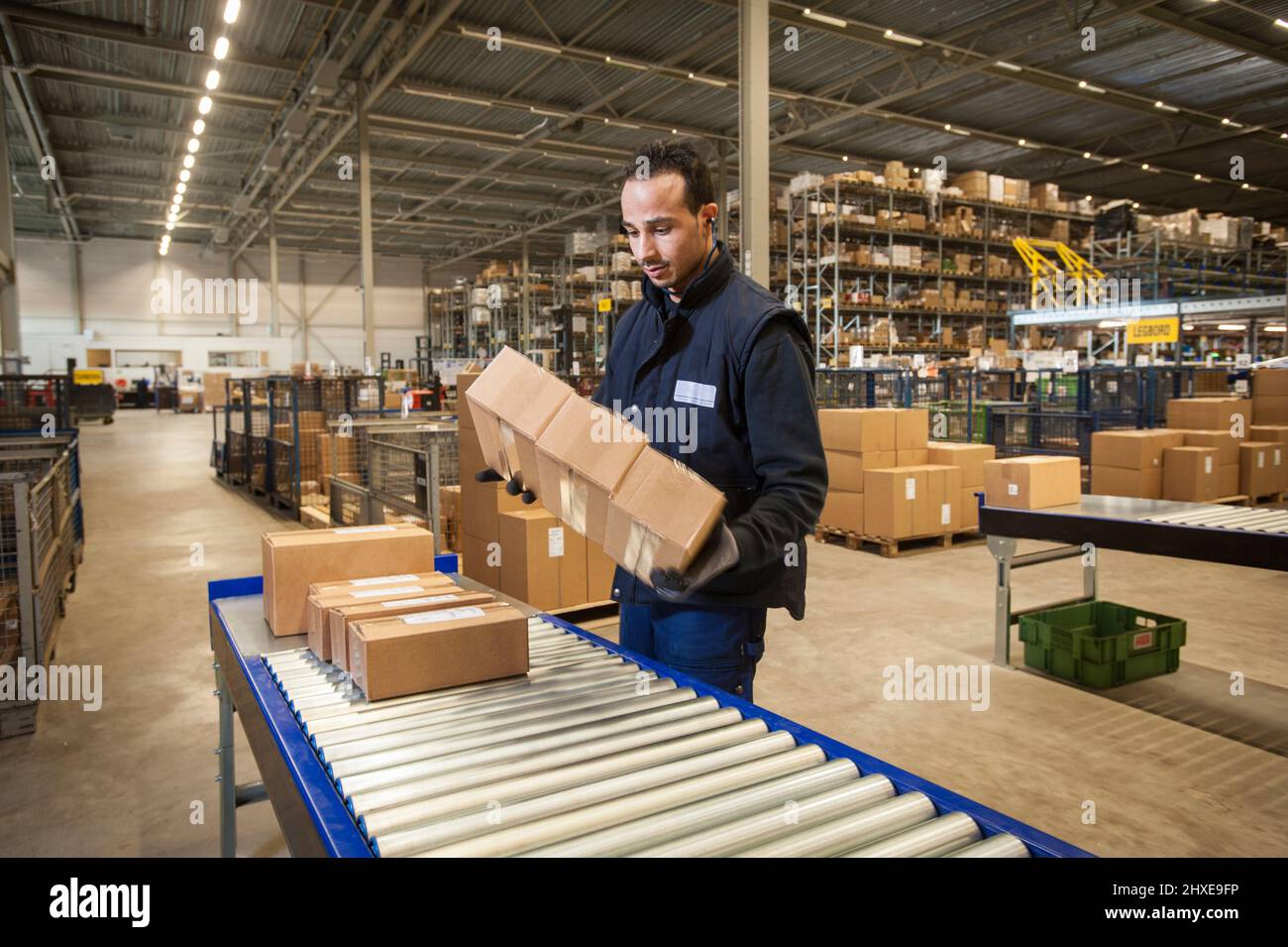 Distribution centre worker sorting packages Stock Photo - Alamy