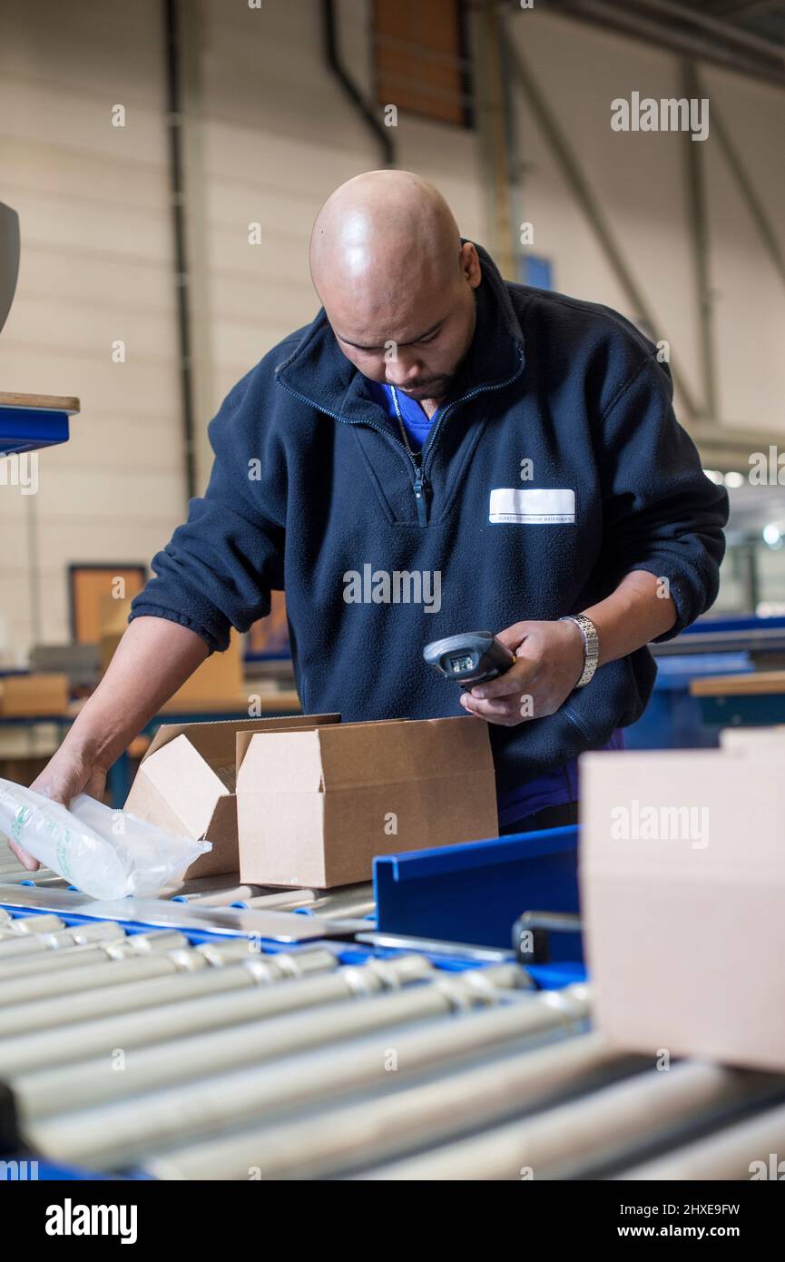 Man using a barcode reader in a warehouse Stock Photo - Alamy
